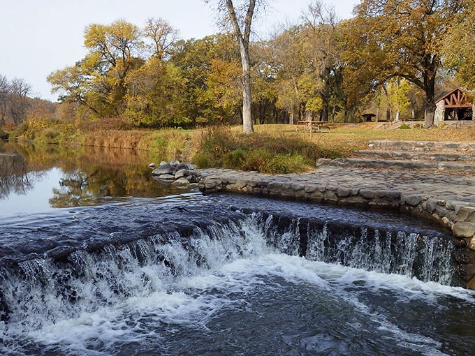 The Turtle River cascades over a stone dam, creating nature's perfect soundtrack for an afternoon picnic.