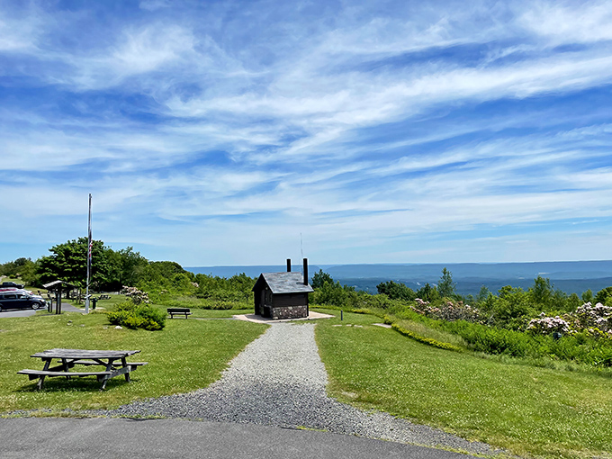 The quintessential Pocono Mountain experience: a rustic stone shelter standing sentinel over miles of rolling Pennsylvania wilderness. Nature's penthouse view awaits.