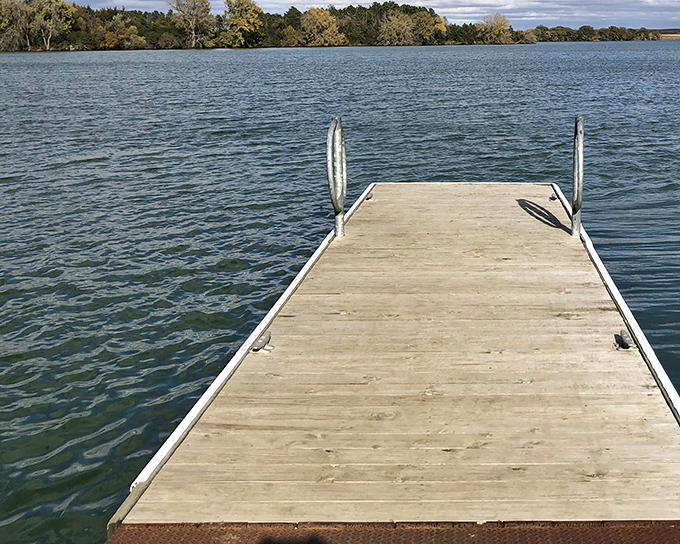 A wooden dock stretches into the serene waters of Oakwood Lakes like an invitation to adventure. Nature's front porch awaits your arrival.