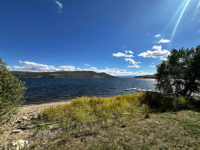 Crystal-clear waters beckoning like a siren's call, with mountains standing guard like ancient sentinels watching over swimmers.