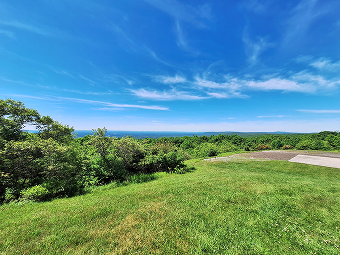 The quintessential Pocono Mountain experience: a rustic stone shelter standing sentinel over miles of rolling Pennsylvania wilderness. Nature's penthouse view awaits.