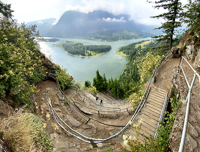 This rustic bridge crossing leads to Hardy Falls, where cascading water meets moss-covered rocks in perfect Pacific Northwest harmony.
