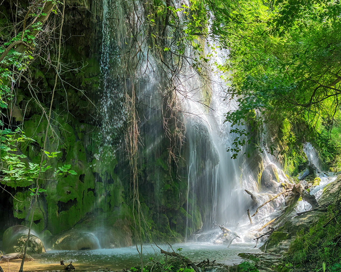 Nature's own masterpiece cascades down moss-covered limestone like something from a fairy tale.