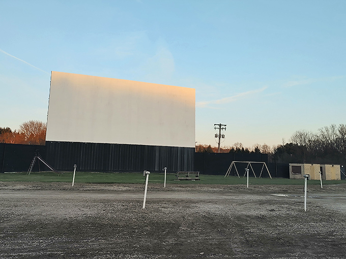 The iconic white screen stands sentinel against the blue sky, waiting for dusk to transform it into a portal to other worlds.