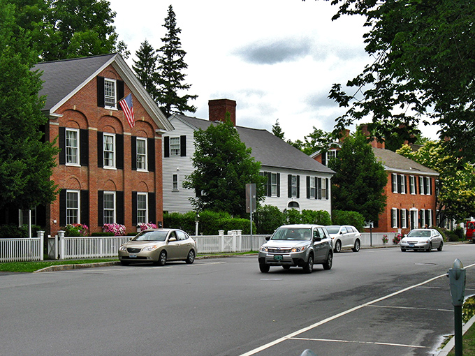 Classic New England charm on full display: Woodstock's historic homes with their pristine white fences stand like sentinels of simpler times.