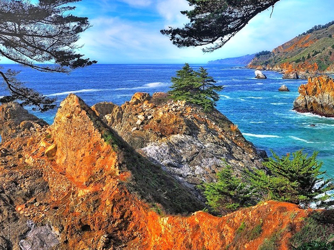 Nature's color palette gone wild! The rusty orange cliffs against that impossible blue ocean create a view that no filter could improve.