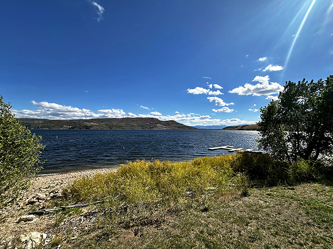 Crystal-clear waters beckoning like a siren's call, with mountains standing guard like ancient sentinels watching over swimmers.