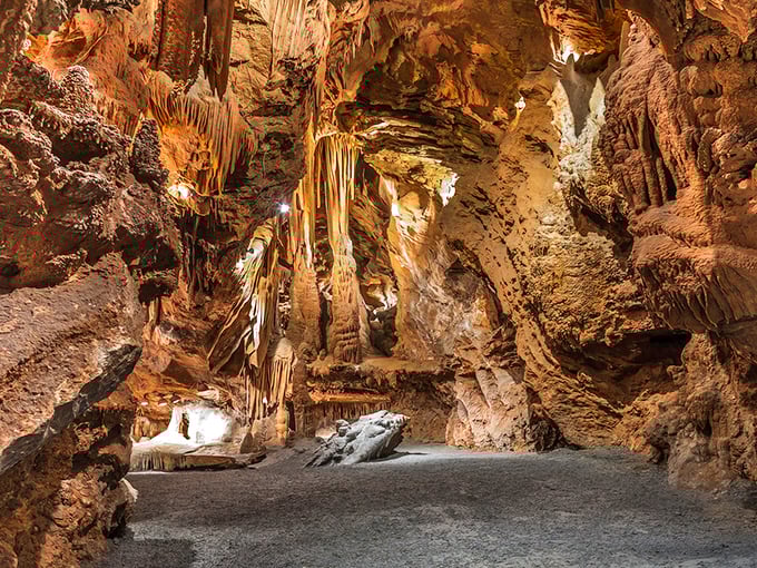 Nature's own art gallery stretches before you, with amber-hued formations creating a corridor that seems designed by some underground Michelangelo.