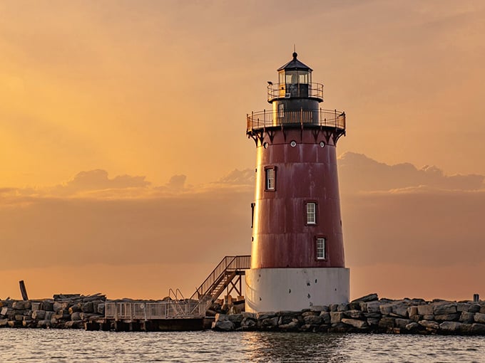 The crimson sentinel stands guard at sunset, its vibrant red tower glowing like a ruby against the golden Delaware sky.
