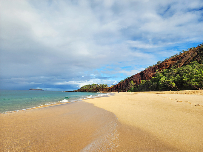 Where golden sands meet volcanic drama – Mākena's Big Beach stretches before you like nature's own red carpet, inviting barefoot exploration.
