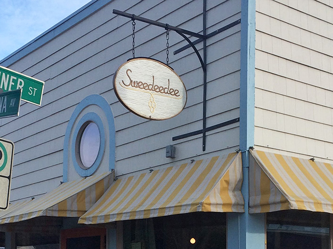 That wooden sign swinging gently above the yellow-striped awning? It's your invitation to breakfast paradise at the corner of North Albina and Sumner.