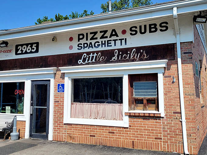The unassuming brick facade of Little Sicily's hides culinary treasures within. Like finding a Picasso at a yard sale, this modest exterior belies the pizza masterpieces inside.