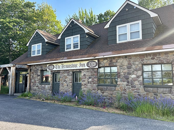 The rustic stone facade of The Brownstone Inn stands like a woodland sentinel, promising comfort and culinary magic within its Upper Peninsula haven.