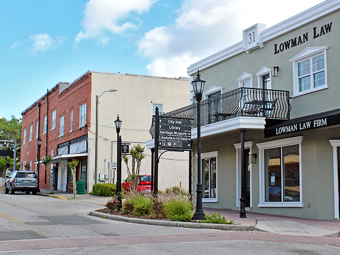 Historic brick meets modern convenience where directional signs point to City Hall, Library, and Heritage Museum &ndash; civilization's greatest hits.