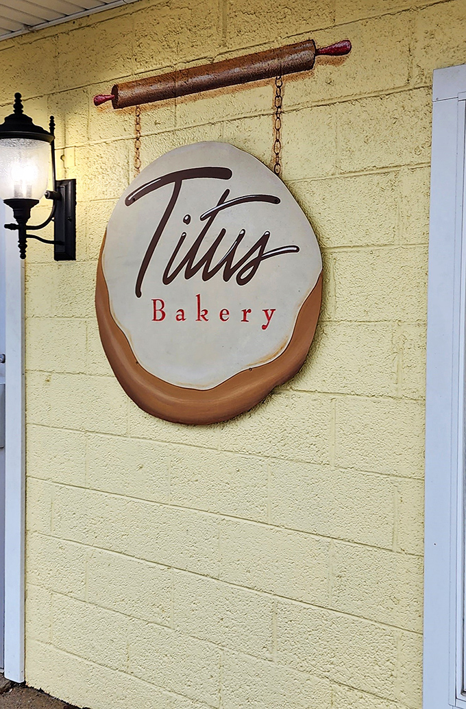 The iconic Titus Bakery sign hangs like a sweet promise against the cheerful yellow exterior. That rolling pin isn't just decoration&mdash;it's foreshadowing.
