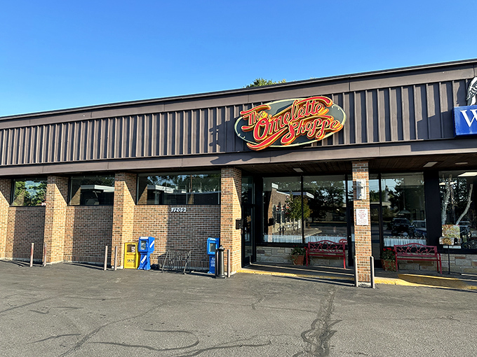 The unassuming exterior of The Omelette Shoppe proves once again that the best breakfast treasures often hide behind modest facades. That red neon sign promises morning magic within.