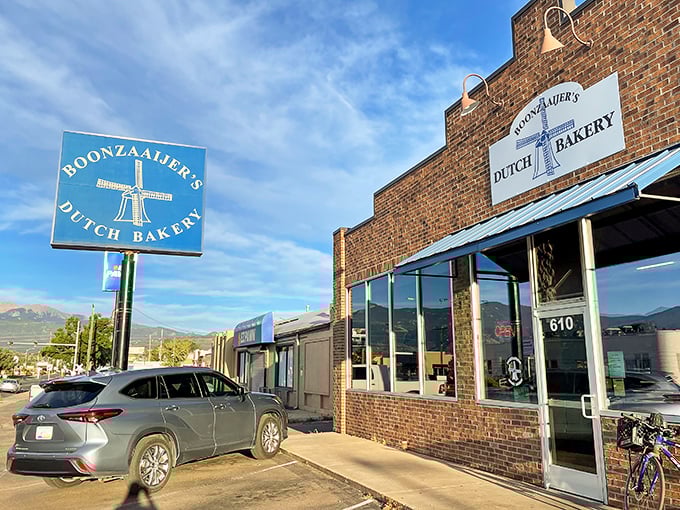 Colorado's blue skies frame this Dutch bakery outpost, where the windmill sign promises authentic European treats with Rocky Mountain views.