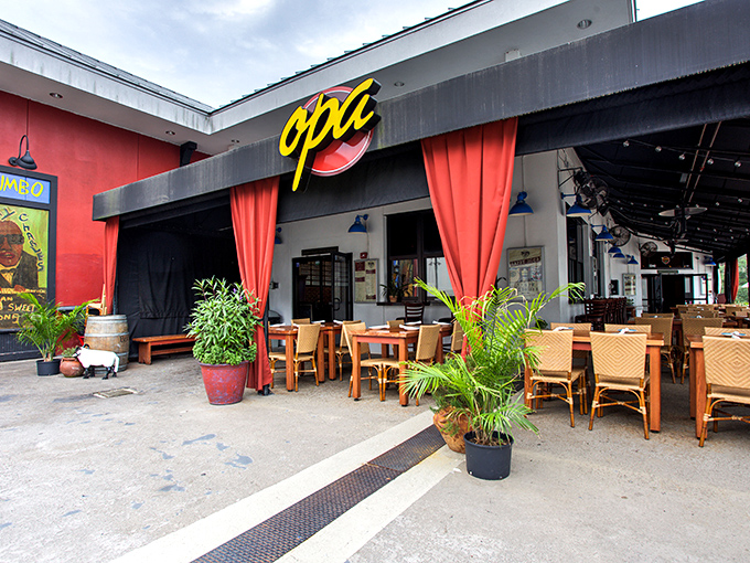 The bright yellow "opa" sign beckons like a Mediterranean lighthouse amid Orlando's tourist corridor. Those red curtains aren't just for show&mdash;they're the gateway to flavor town.