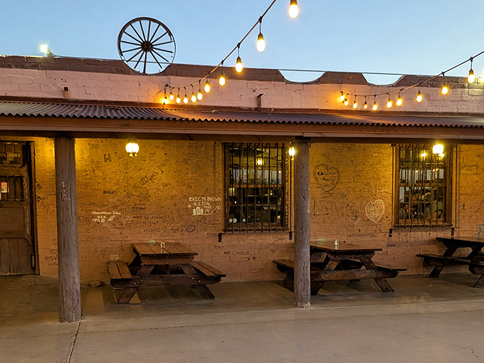 The rustic adobe exterior of Li'l Abner's glows with string lights at dusk, promising carnivorous delights within those weathered walls.