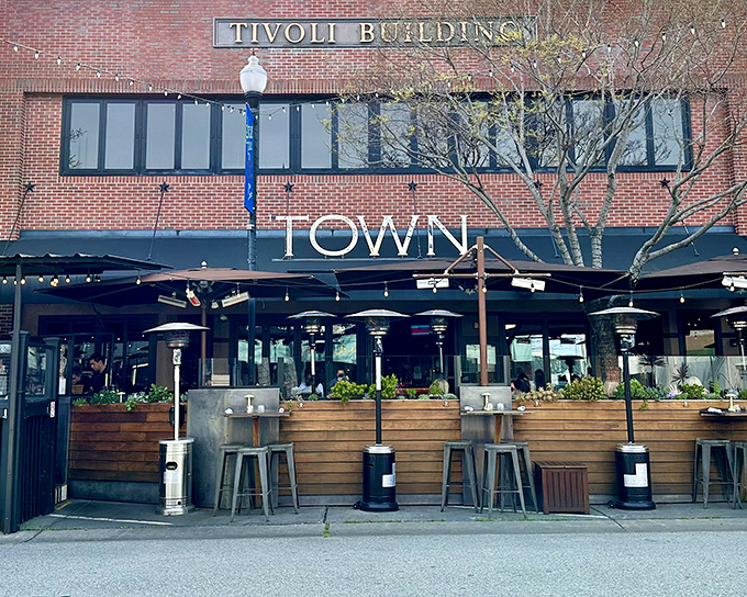 Town's welcoming exterior in the historic Tivoli Building beckons hungry passersby with its simple yet confident signage and inviting patio setup.