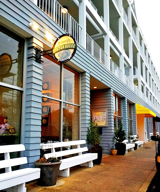 Coastal charm meets urban sophistication with the restaurant's welcoming exterior, where white benches invite you to pause before diving into oceanic delights.