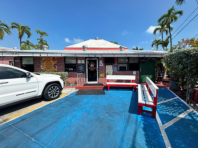 Palm trees stand guard outside this Key West institution. The blue concrete patio and red benches hint at the colorful flavors waiting inside.