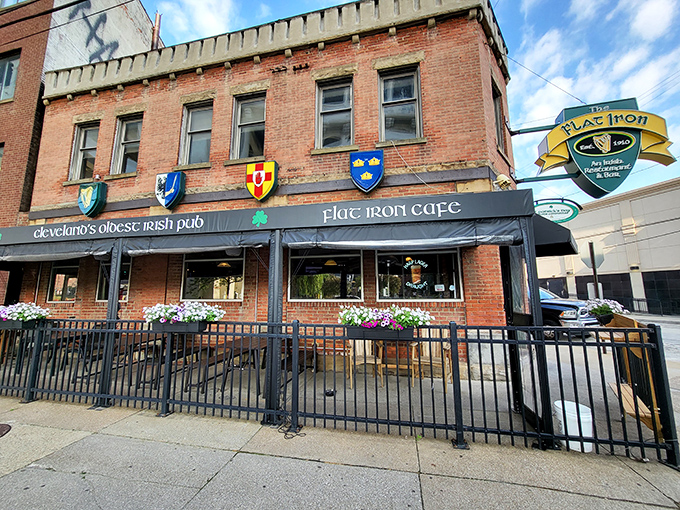 The brick facade of Flat Iron Cafe stands proudly in Cleveland's Flats district, its heraldic shields and flower boxes offering a warm Irish welcome.
