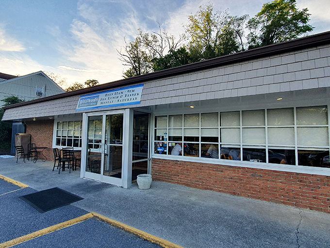 Twilight transforms this modest storefront into a beacon for food lovers. The blue sign promises what every weary soul needs: lunch, dinner, and the sweet possibility of dessert.