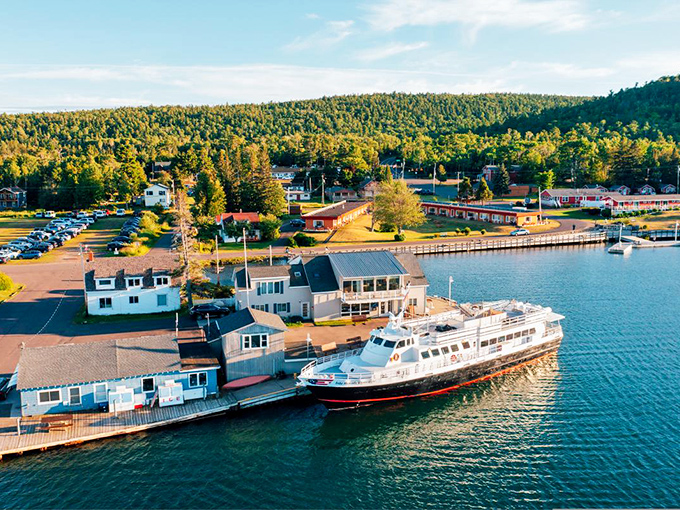 Aerial paradise where wilderness meets water. The Isle Royale Queen IV stands ready at the dock, promising adventures across Lake Superior's vast blue canvas.
