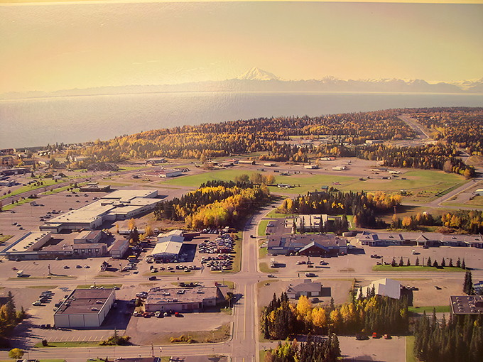 Kenai's autumn aerial view showcases nature's paintbrush at work. Golden trees frame the town while mountains stand guard in the distance.