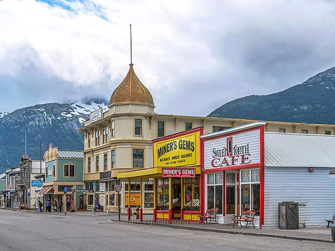 Skagway&rsquo;s iconic Broadway storefronts sit beneath towering mountains, blending Gold Rush charm with modern-day shops and caf&eacute;s.