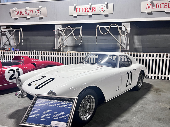 This pristine white Ferrari 250 GT Berlinetta sits quietly under the "Ferrari" sign, like a movie star pretending not to notice everyone staring.