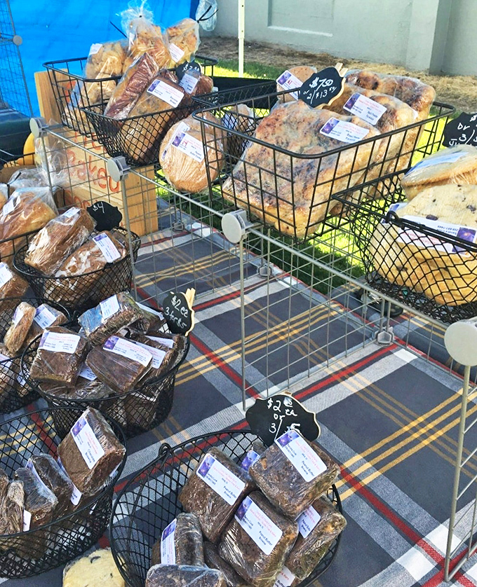 Fresh-baked temptations lined up like delicious soldiers, each loaf a battlefield where willpower goes to surrender deliciously.