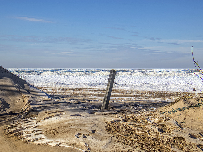 Winter transforms Porter Beach into a snow-globe landscape where the lake freezes into otherworldly ice sculptures.