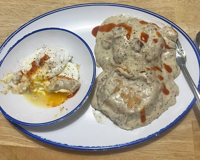 Biscuits smothered in gravy with enough pepper specks to count as modern art, alongside eggs that look like little suns on a cloudy day.