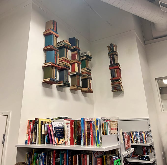 Books stacked like literary Jenga, where Danielle Steel mingles with dusty dissertations in democratic disorder.