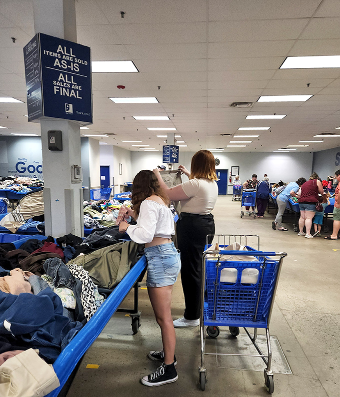 The unspoken choreography of outlet shopping – carts, bins, and bargain hunters moving in a well-practiced dance of discovery.