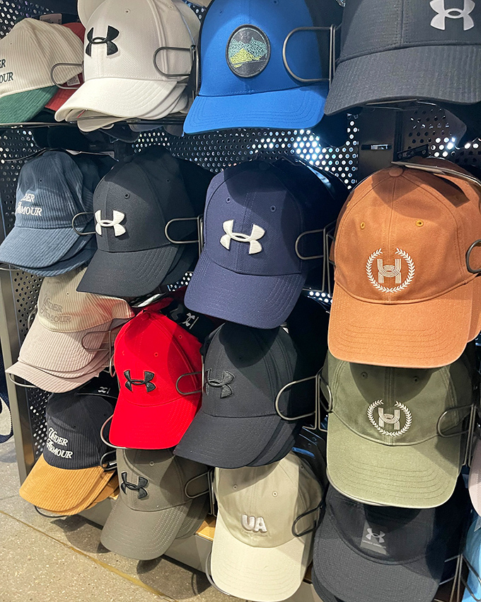 A wall of Under Armour caps offers headwear for every personality&mdash;because even your crown deserves designer treatment without the royal price tag.