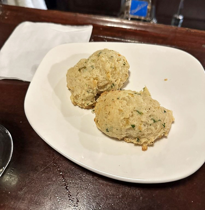 These aren't just cheddar biscuits—they're pillowy clouds of cheesy goodness that make waiting for your entrée a pleasure, not a chore.