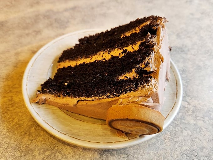 A slice of chocolate cake with layers so defined they deserve their own Instagram account. Dessert that demands to be eaten, not photographed.