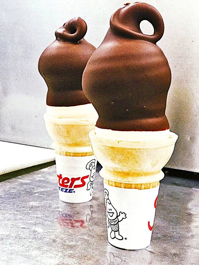 Chocolate-dipped soft-serve cones standing at attention like delicious soldiers ready to battle your hunger with sweet, cold reinforcements.