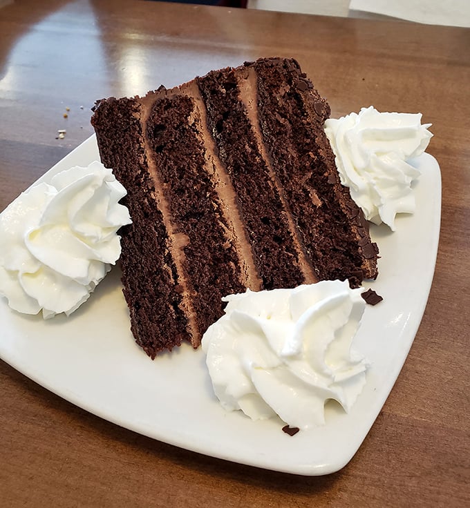 Four layers of chocolate decadence surrounded by pillowy whipped cream. The kind of cake that makes you consider skipping the seafood entirely. Almost.