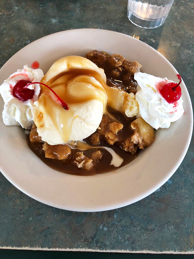 Apple crumble à la mode with whipped cream and cherries—because sometimes dessert should look like it's celebrating something even if that something is Tuesday.