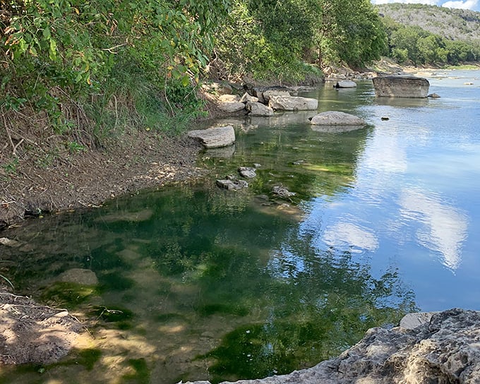 The Colorado River creates mirror-like reflections that double the beauty of surrounding canyon walls.