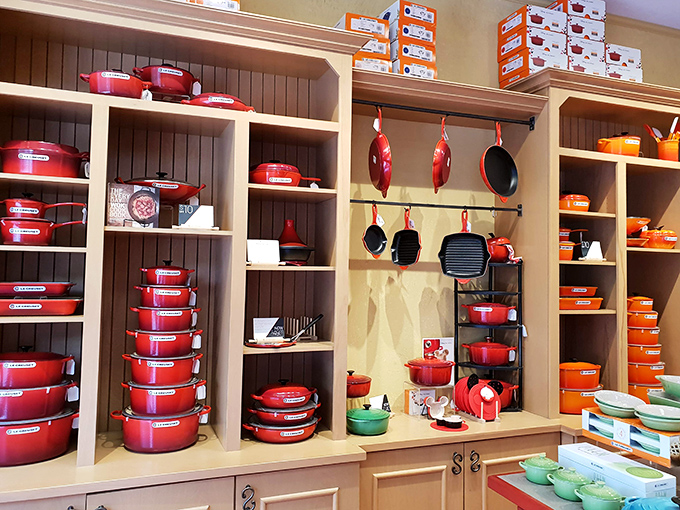 Le Creuset heaven in flame orange and cherry red. Kitchen dreams materialize in cast iron, making you suddenly passionate about braising meats you've never considered cooking.