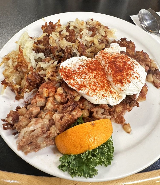 Crispy, savory corned beef hash with eggs that could make a rooster proud. The orange slice is just pretending this isn't pure indulgence.