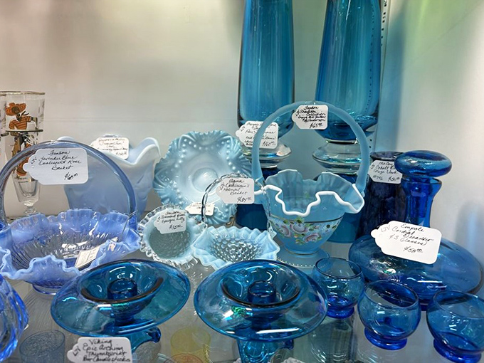 Blue glassware catching light like liquid sky – each piece tagged with history and priced less than you'd pay for a fancy coffee.