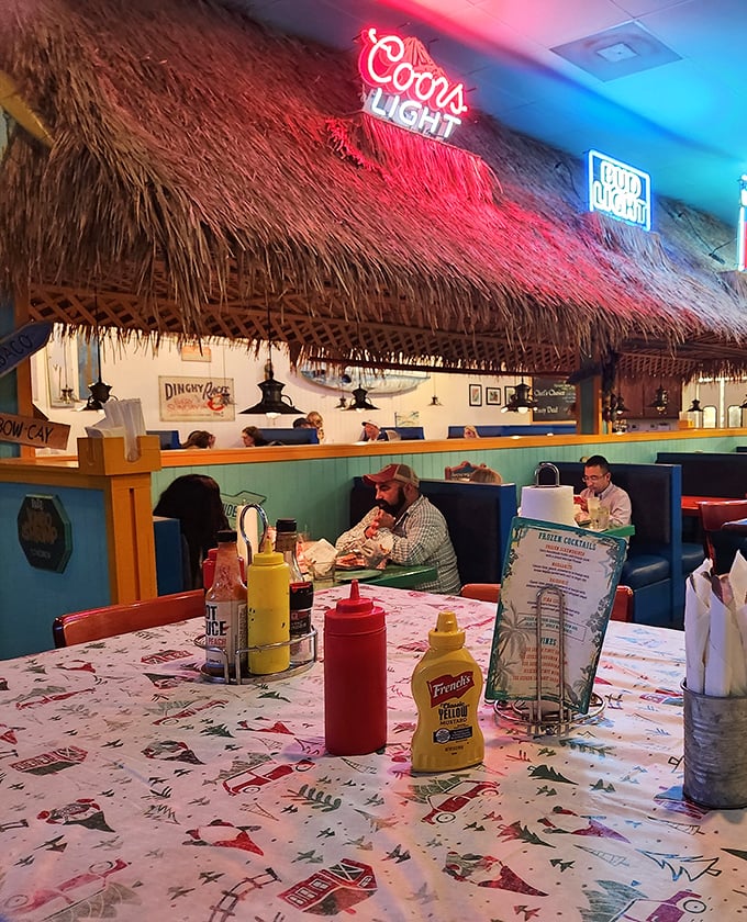 Red neon beer signs cast a warm glow over the thatched bar area, where condiments stand ready for whatever wild creation arrives.