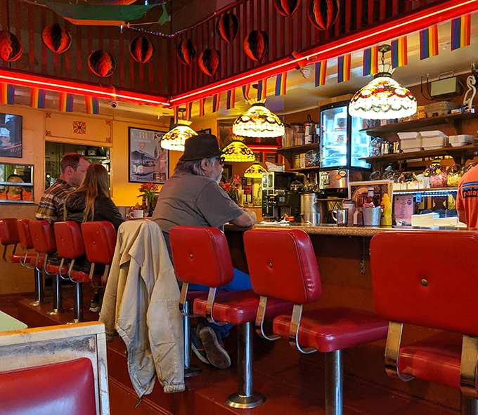 Classic diner counter seating where solo diners become instant friends over shared appreciation for perfectly griddled hash browns.