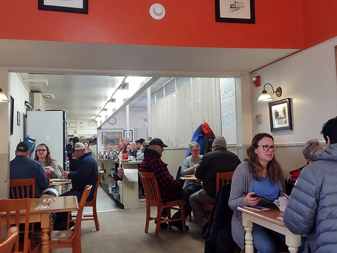 Where strangers become neighbors over coffee. The red accent wall adds warmth that matches the conversation.